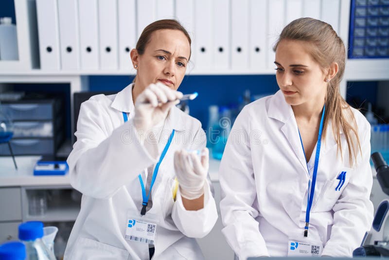 Two Women Scientists Using Laptop Holding Pill at Laboratory Stock ...