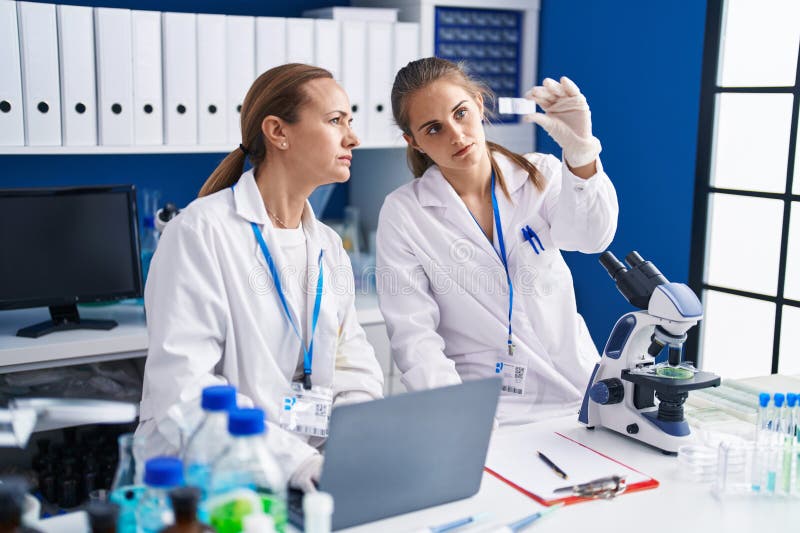 Two Women Scientists Using Laptop Holding Sample at Laboratory Stock ...
