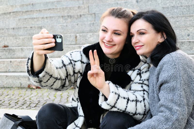 Two Women Sitting Outside on Stairs and Making a Selfie Stock Image ... Two Women Sitting Outside on Stairs and Making a Selfie Stock Image ...