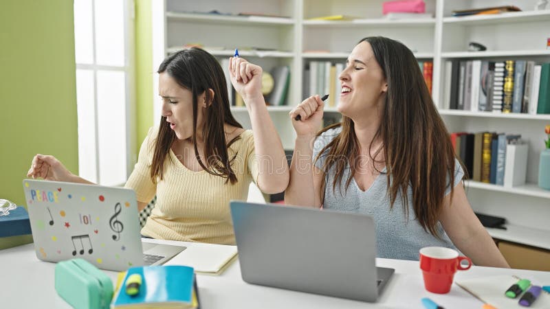 Two Women Sitting on Table Singing Song Studying at Library University ...