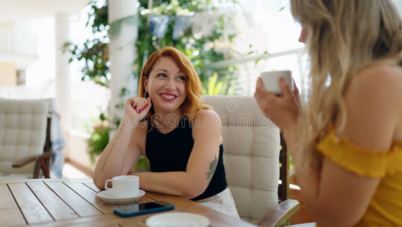 Two Women Sitting on Table Speaking and Drinking Coffee at Home Terrace ...