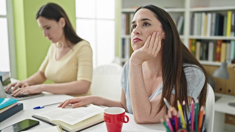 Two Women Sitting on Table Studying with Boring Expression at Library ...