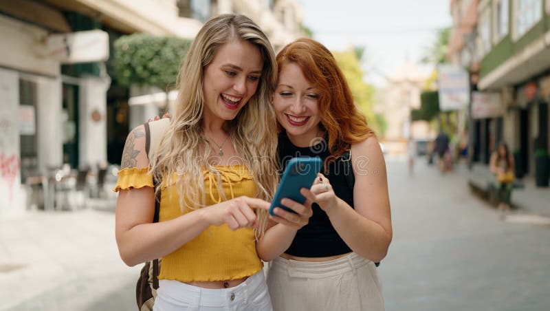 Two Women Standing Together Using Smartphone at Street Stock Image ...
