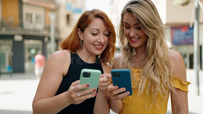 Two Women Standing Together Using Smartphones at Street Stock Image ...