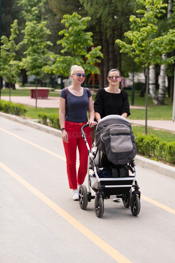 Two Women Strolling with a Baby Stroller Stock Image - Image of ...