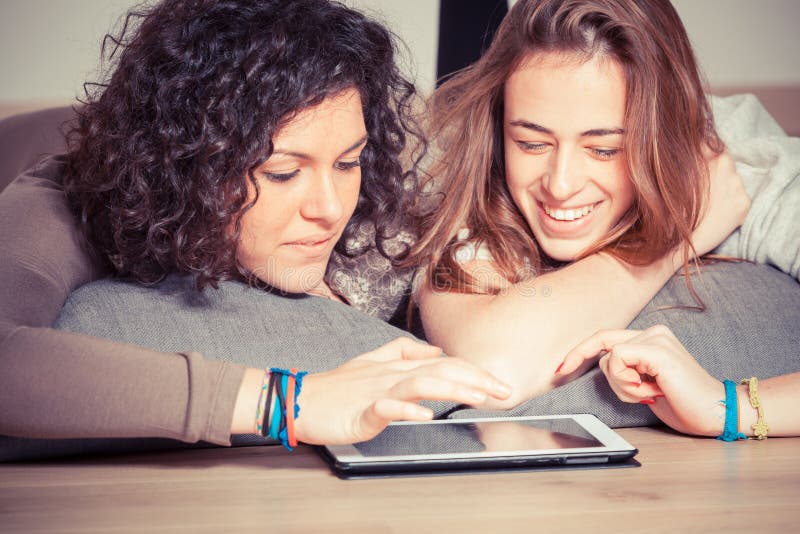 Two Women with Tablet PC stock photo. Image of prone - 28175262