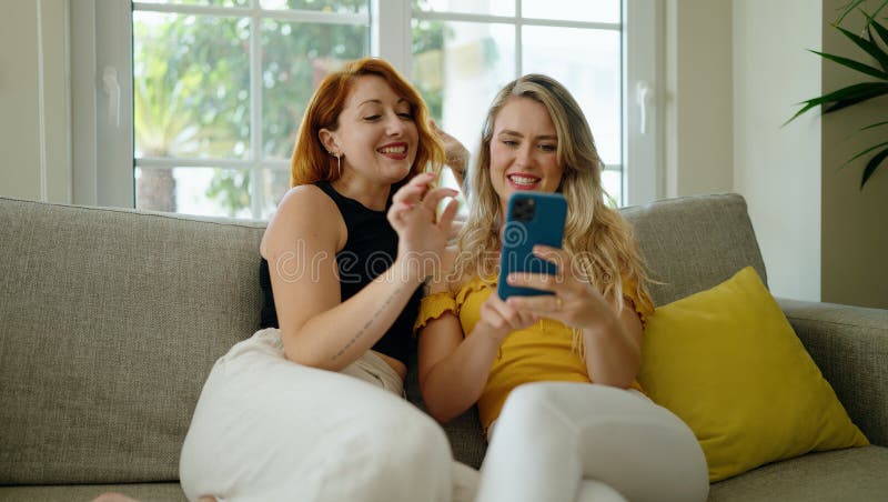 Two Women Using Smartphone Sitting on Sofa at Home Stock Image - Image ...