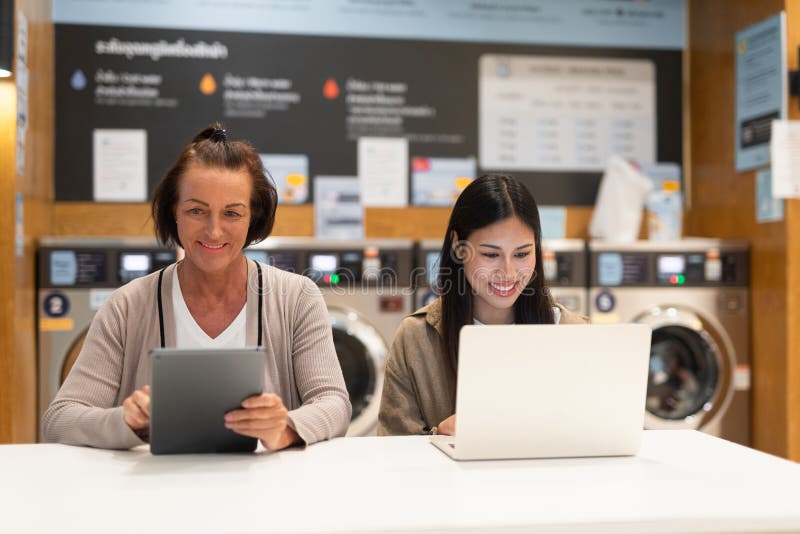 Two Women Working on a Computer in Laundry Shop Stock Photo - Image of ...