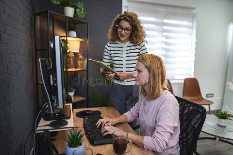Two Women Working on a Computer in an Office Stock Image - Image of ...