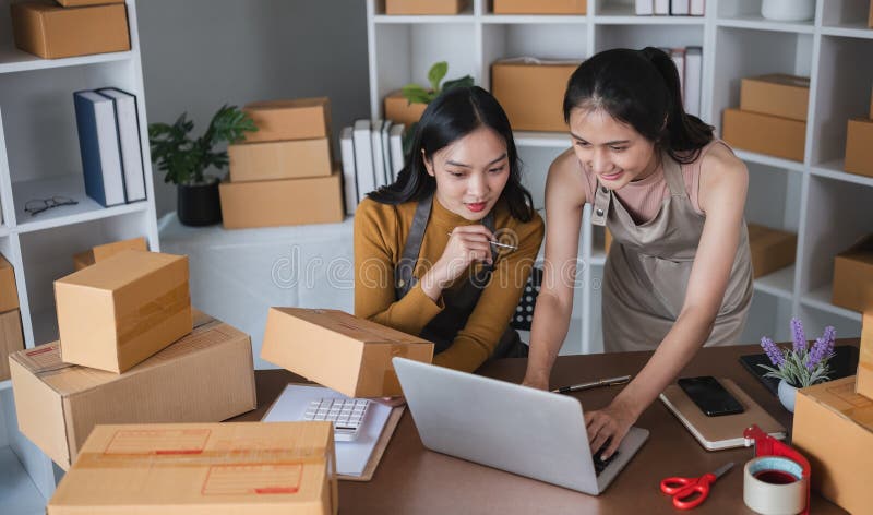 Two Women Working on Laptop and Packing Boxes in Warehouse Stock Photo ...