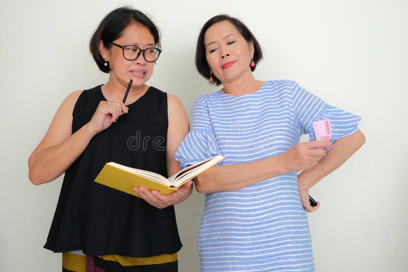 Two Women Writing Business Plan on a Book, while Another Holding the ...