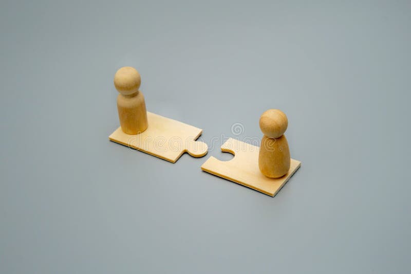 Two Wooden Figures Stand on Puzzle Pieces Facing Each Other. Stock ...