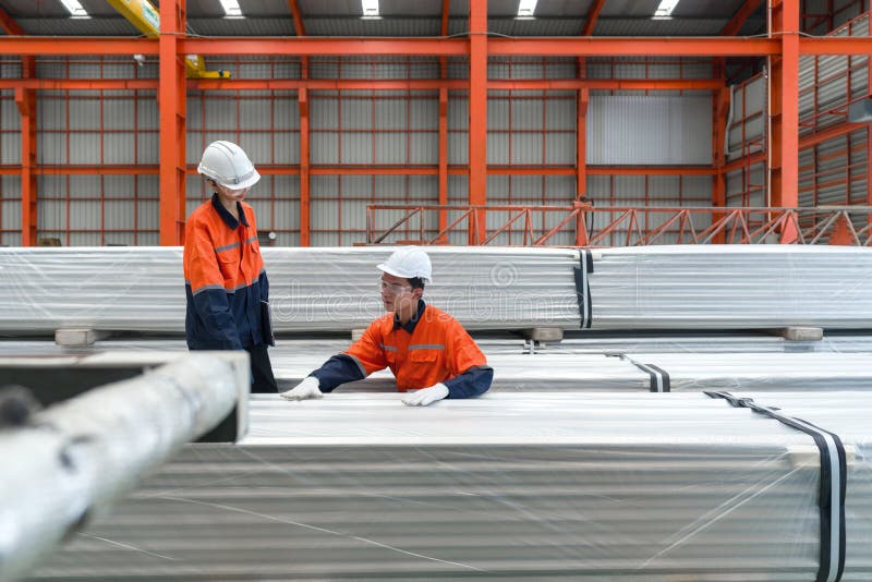 Two Worker in Safety Gear are in a Warehouse. they are Checking ...