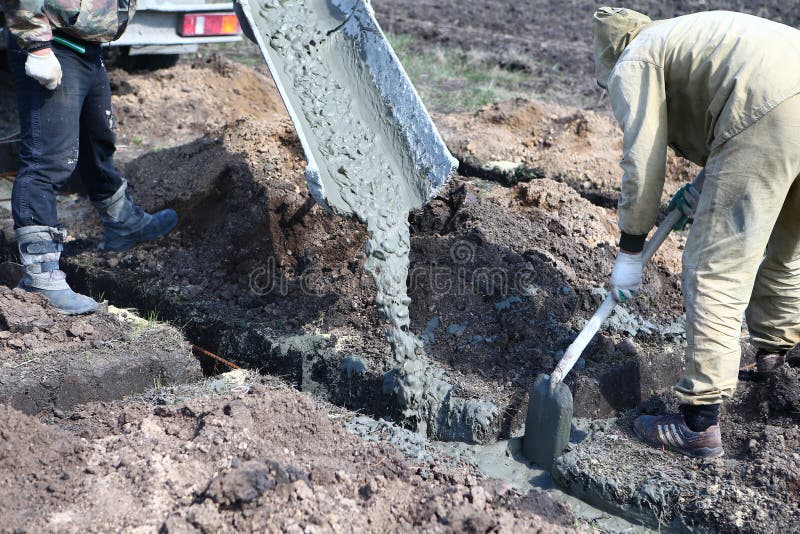 Two Workers-builders Fill in Concrete Consisting of Cement and S ...