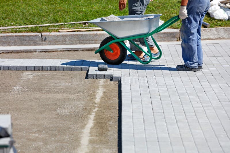 Workers Transport Paving Slabs in a Construction Wheelbarrow on a ...