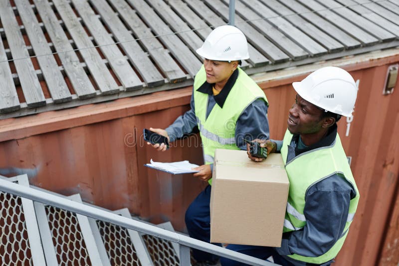 Two workers carrying boxes stock image. Image of export - 262065265