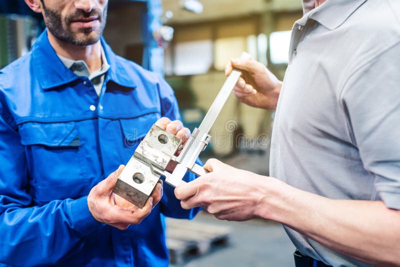 Two Workers Checking Measurements of Work Piece in the Factory Stock ...