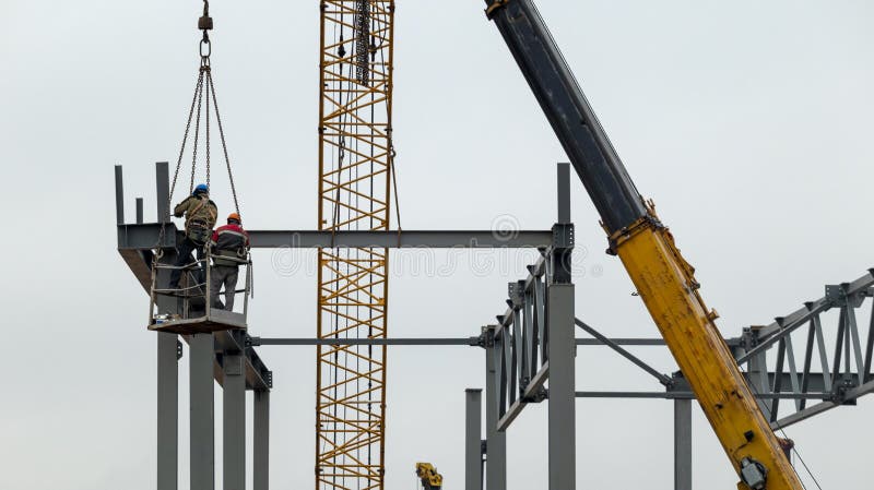 Two Workers at a Construction Site are Assembling the Frame of a ...