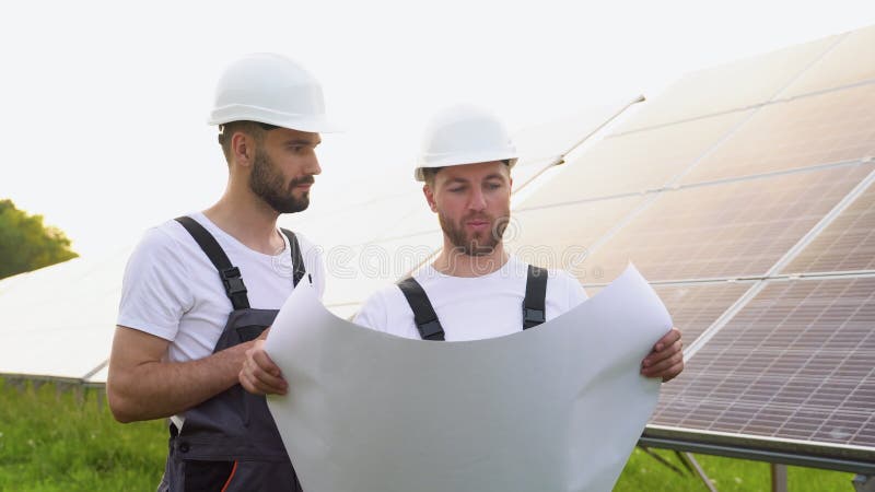 Two Workers Engineers Talking with Each Other while Holding a Blue ...