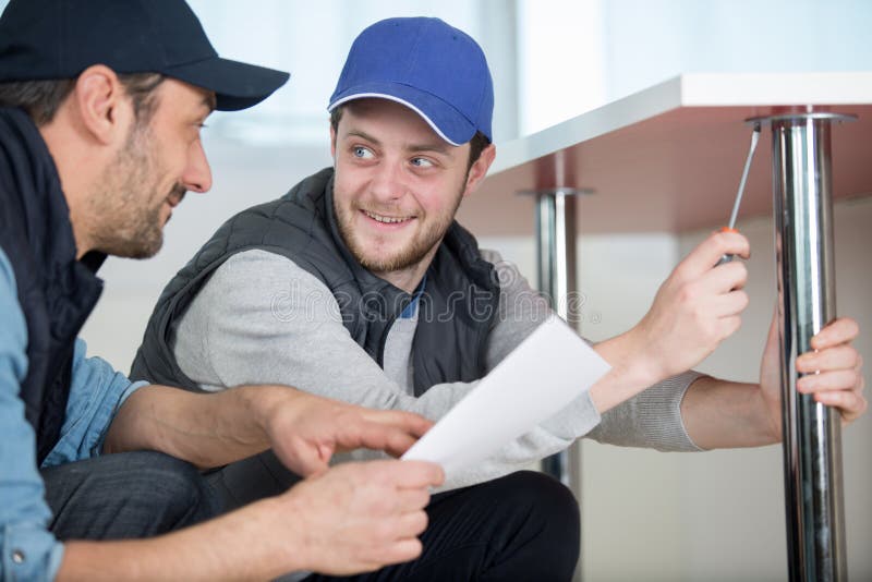 Two workers fixing chair stock photo. Image of hammer - 260341824