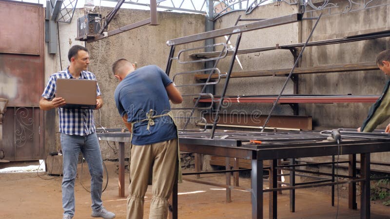 An Engineer with a Laptop in a Workshop for the Production of Metal ...