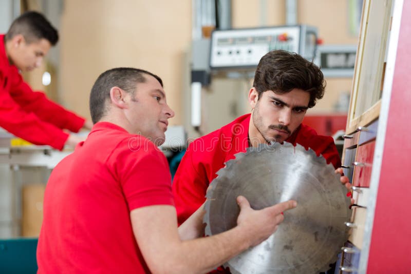Two Workers Inspecting Jagged Blade Stock Image - Image of serious ...