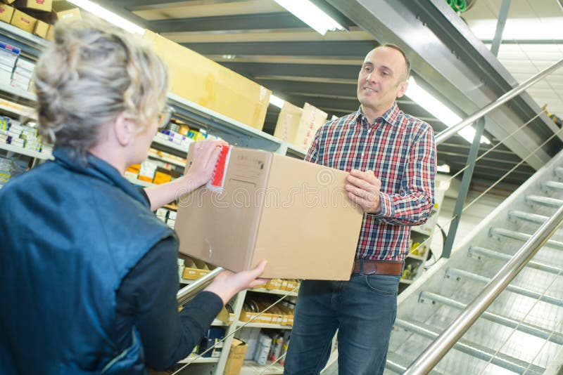 Two Workers Lifting Cardboard Box at Warehouse Stock Image - Image of ...