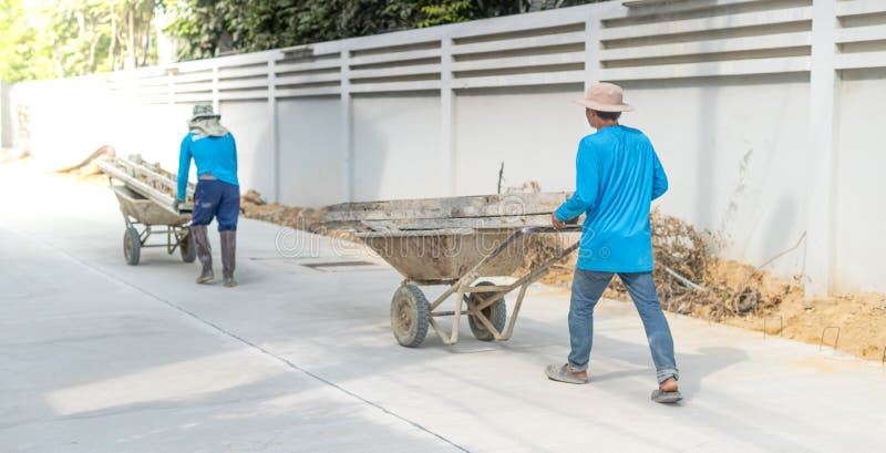 Two Worker Man Pullinng the Cement Cart for Mixing the Cement for ...