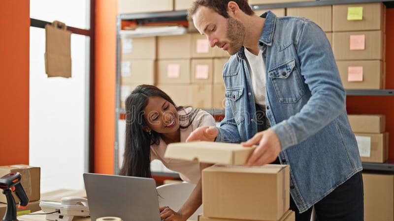 Two Workers Man and Woman Using Laptop Putting Packages on Table at ...