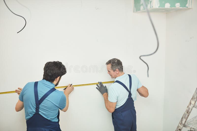 Two Workers Measuring Wall stock photo. Image of adult - 172807690