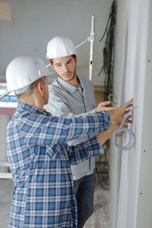 Two Workers Mounting Wires in Construction Site Stock Image - Image of ...