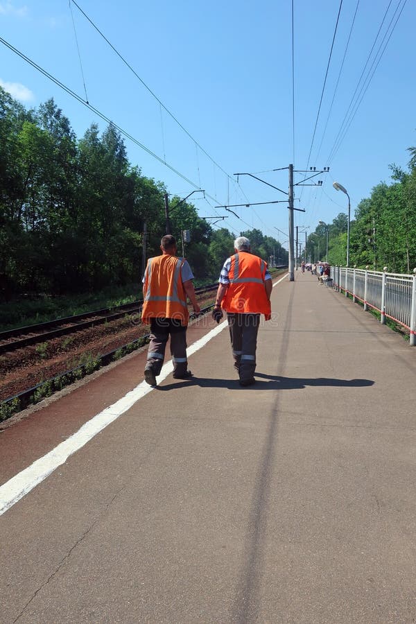 Two Workers in Orange Vests Walk on a Railway Platform Editorial Stock ...