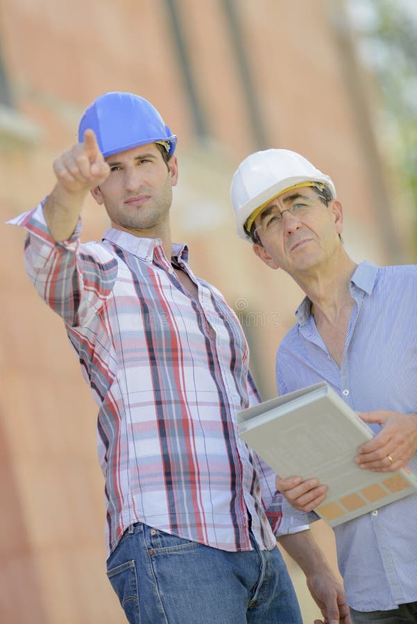 Two workers survey site stock photo. Image of construction - 265994216