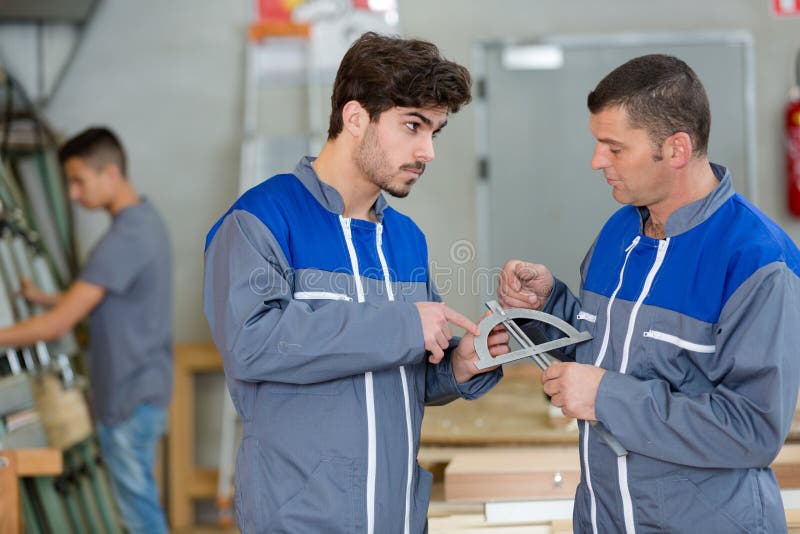 Two Workers Talking while Holding Ruler Stock Image - Image of ...