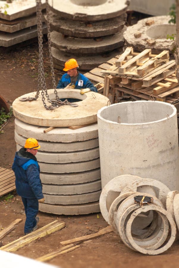 Two Workers Unload Concrete Rings at a Construction Site Editorial ...