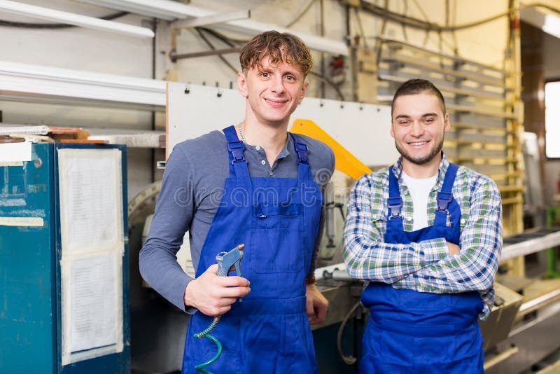 Two Workers Working on a Machine Stock Photo - Image of ladder ...