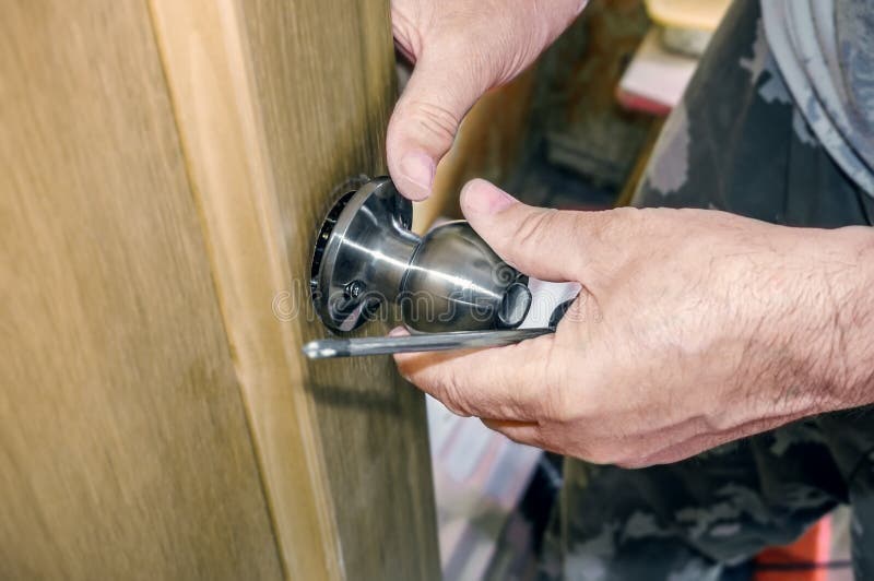 Two Working Hands of a Carpenter when Installing a Lock in a Wooden ...