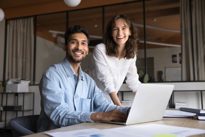 Two Workmates Posing in Modern Workplace, Laughing, Looking at Camera ...