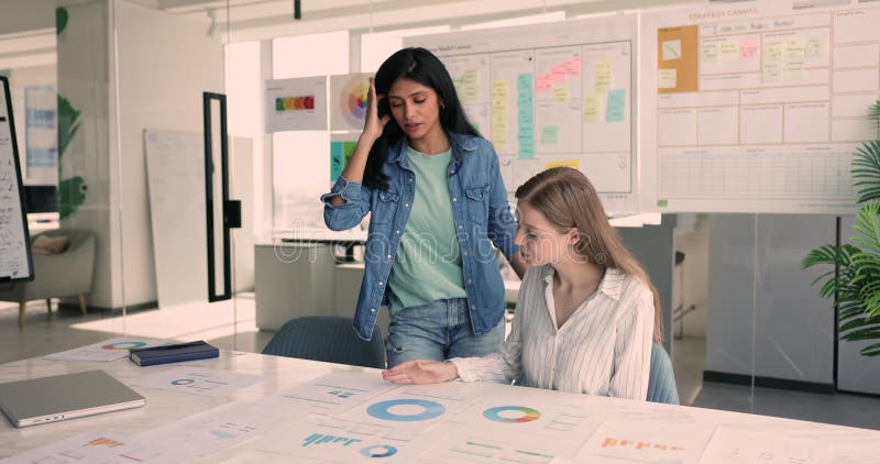Two Workmates Review Paperwork with Infographics Data Stock Footage ...