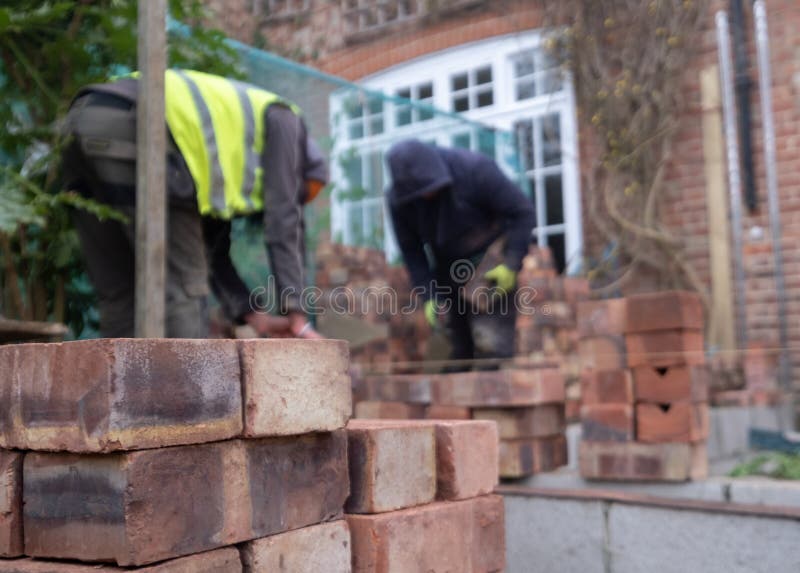 Two Construction Workers Laying Bricks As Part of a Renovation of an ...
