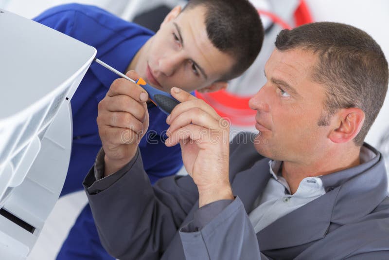 Two Workmen Carefully Unscrewing Stock Photo - Image of appliance ...