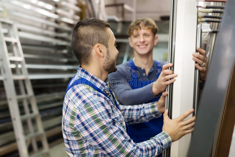 Two workmen choosing PVC stock image. Image of assembly - 48875517