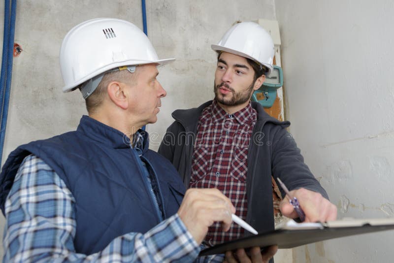 Two workmen in discussion stock photo. Image of clipboard - 118894834