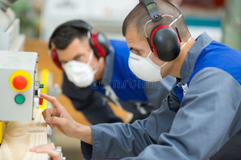 Two Workmen Operating Machines Stock Image - Image of back, mature ...