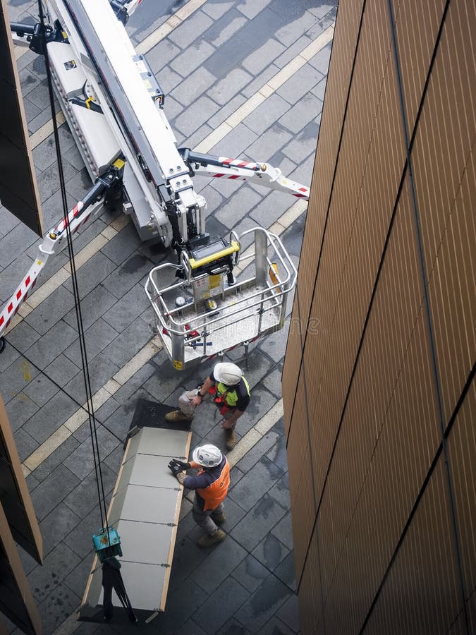 Two Workmen Preparing Hoisting Operation of a Building Panel Using a ...