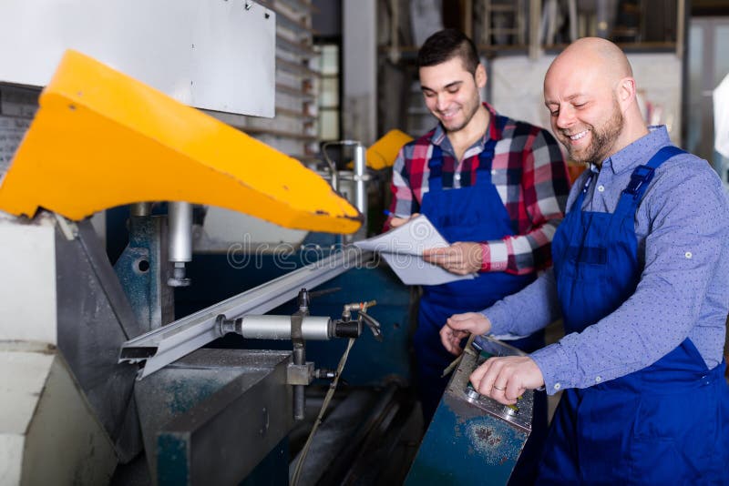 Two workmen in PVC shop stock photo. Image of security - 79969764