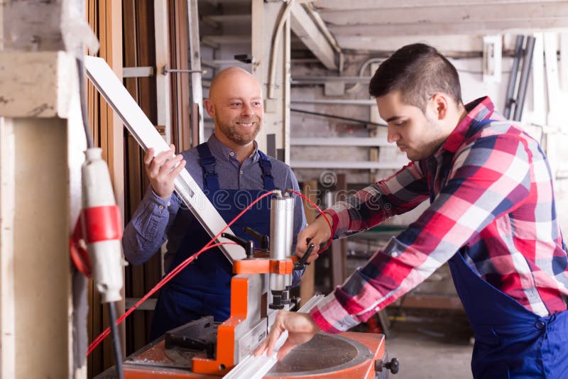 Two workmen in PVC shop stock image. Image of facility - 60762985