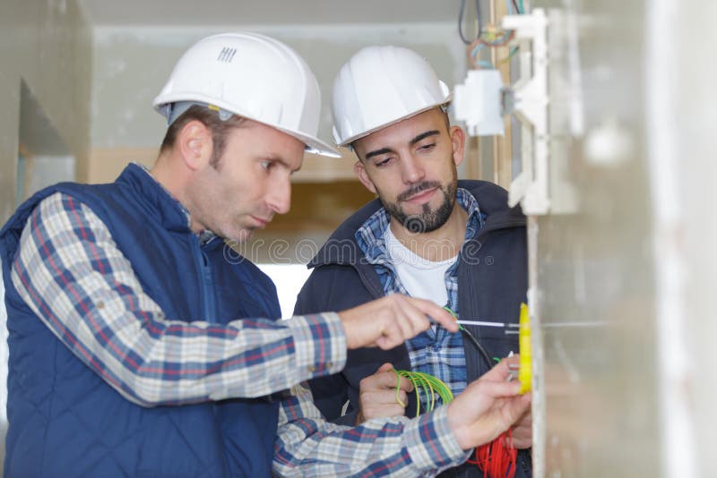 Two Workmen Screwing Electric Terminal To Wall Stock Image - Image of ...