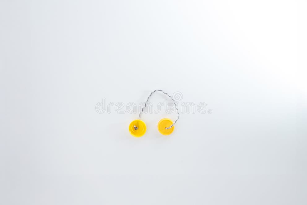 Two Yellow Plastic Bottle Caps Connected by String. Creative Use of ...