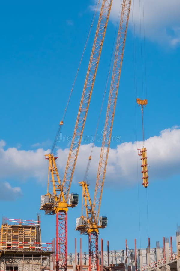 Two Yellow Tower Cranes and Unfinished Building Construction Against ...